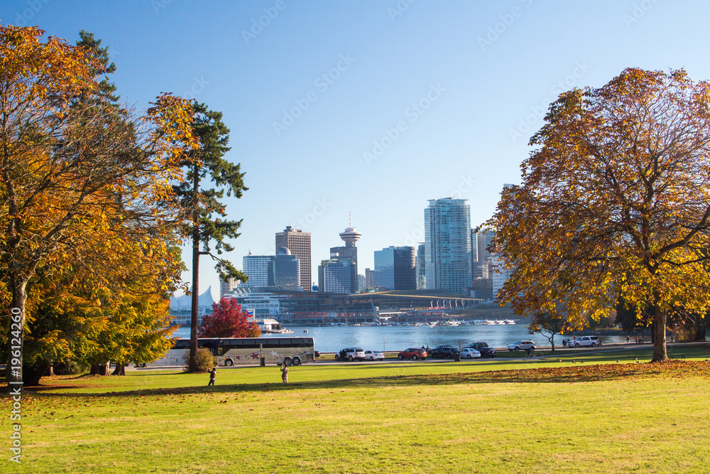 Towers of a big city appearing in between of autumn colorful trees of ...