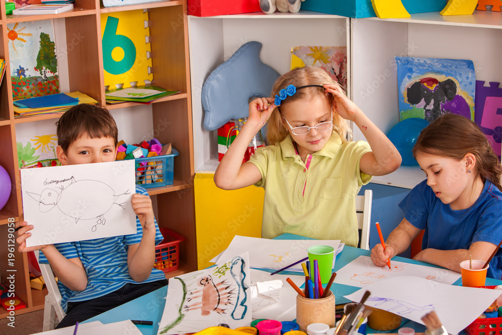 Foto de Small students girl and boy painting in art school class. Child ...