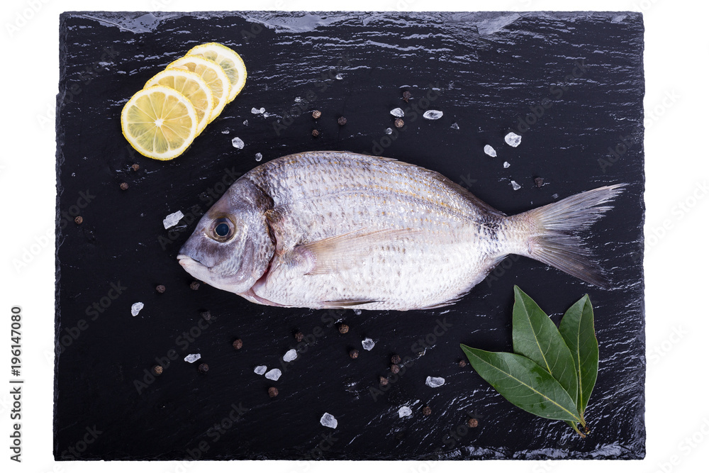 Sea bream with bay leaves, lemon slices, pepper corns and rock salt on ...