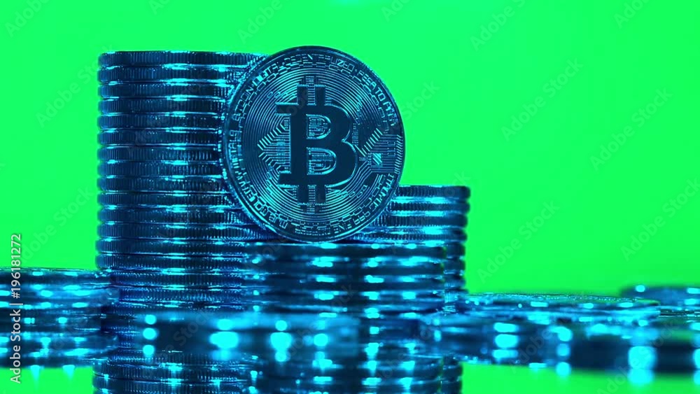 Bitcoins in blue light on green background. Crypto currency Gold Bitcoin, BTC, Bit Coin ...