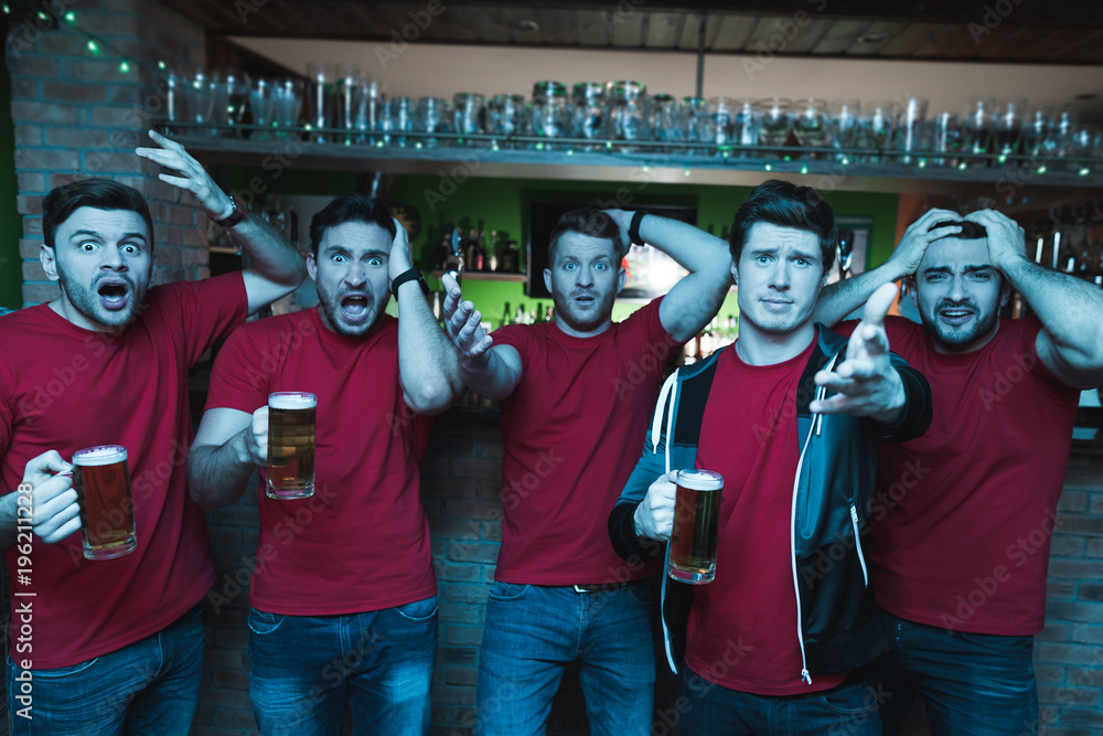 Sports fans shouting sad in front of tv drinking beer at sports bar ...