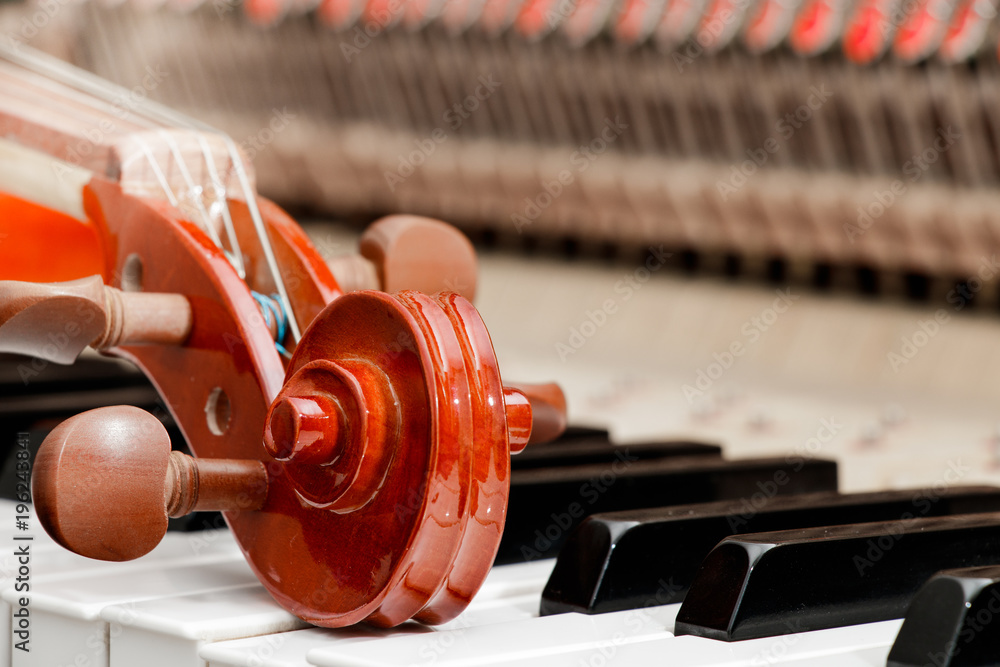 classic brown violin on the close up image of grand piano keys and ...