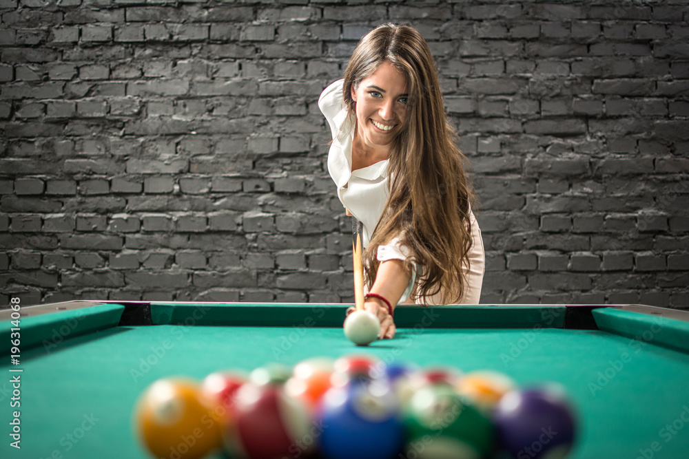 Happy business woman playing a game of billiards and preparing to break ...