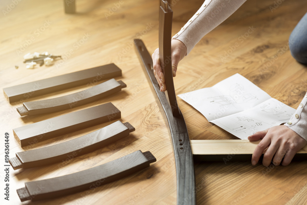 Assembly of wooden furniture, a woman putting together the wooden parts ...