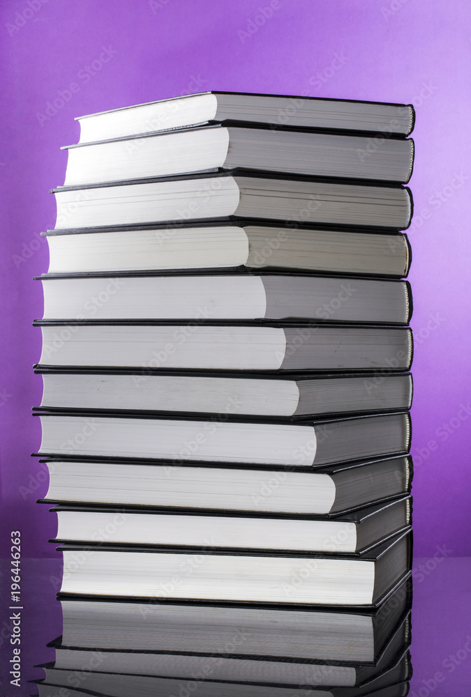 Stack of books on a purple background Stock Photo | Adobe Stock