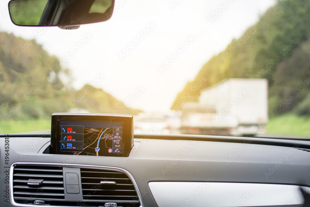 Satellite navigation system device in car with blurred transportation ...
