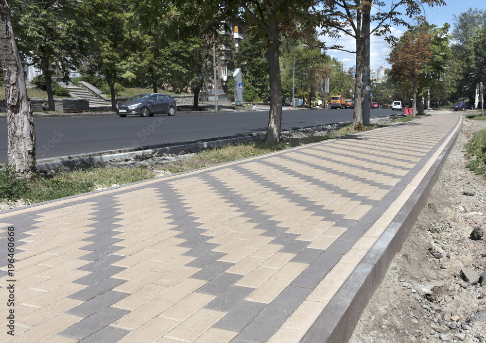 The pedestrian walkway of the city is paved with a new paving slab ...