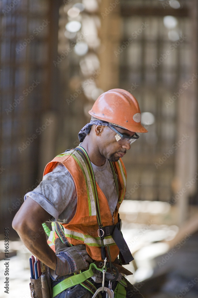 Dirty mid-adult construction worker wearing a helmet and hi-visibility ...