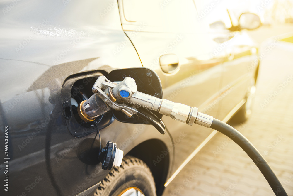 car fuel up with gas. close up refueling gun in the neck of the tank ...