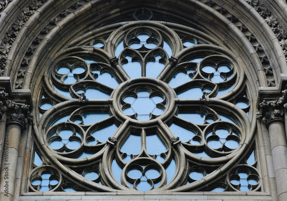 Round window with stained glass on facade of the building. Baroque and ...