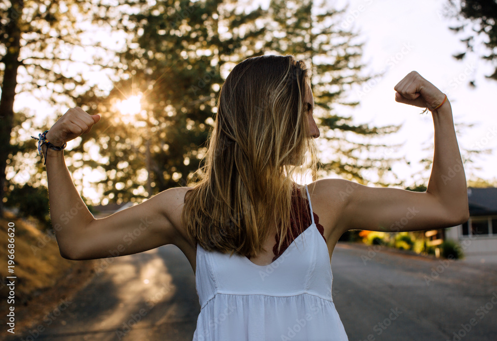 Strong teenage girl flexing her muscles Stock Photo | Adobe Stock