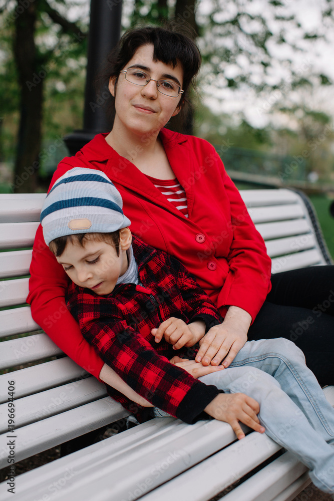 Older sister sitting on the bench with her brother with infant cerebral ...