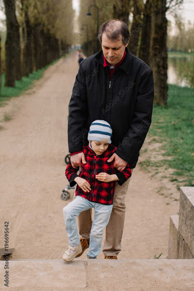 Father helping his son with infant cerebral paralysis go up the ladder ...