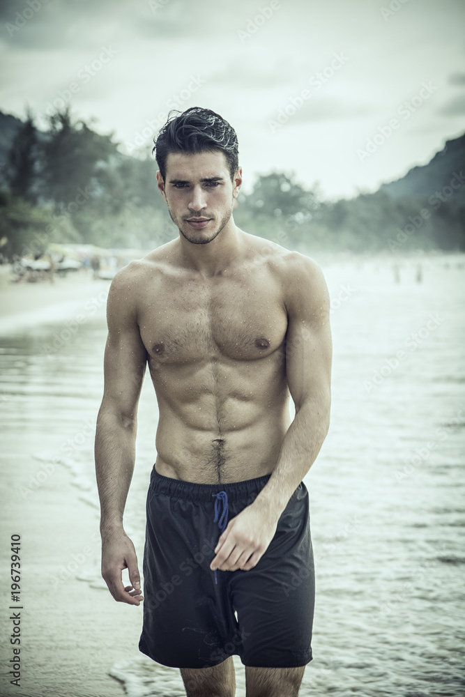 Half body shot of a handsome young man standing on a beach in Phuket ...