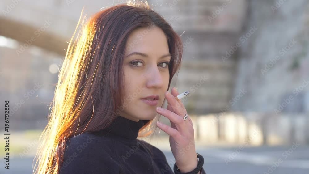 sensual brunette smoking cigarette staring at camera- slow motion ...