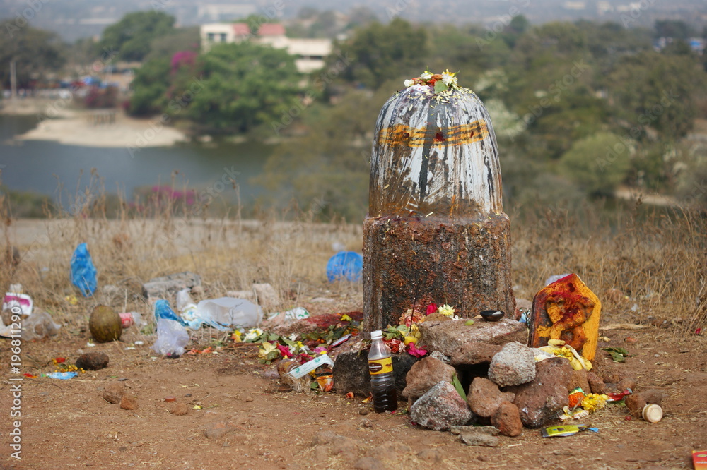 Hindu People offer prayers or do puja to stone ancient carved linga ...