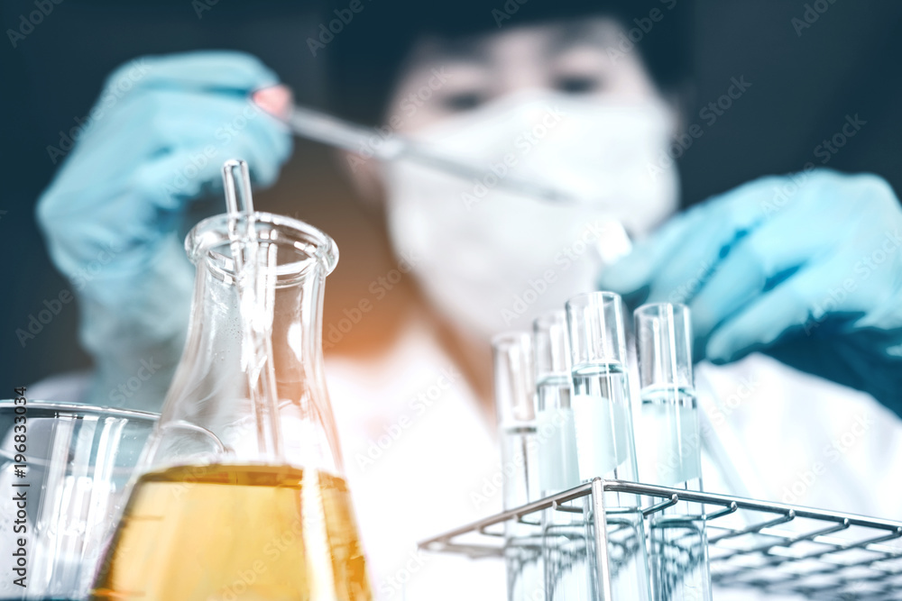 Scientist dropping chemical liquid to flask in lab Glass laboratory ...
