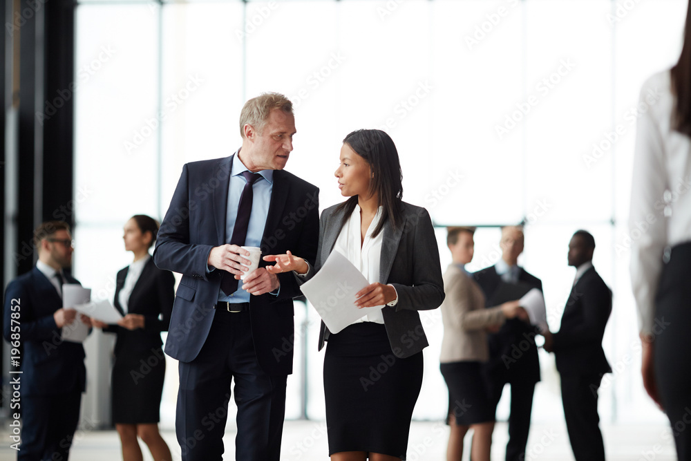 Mature delegate and his young colleague having discussion of ideas for ...