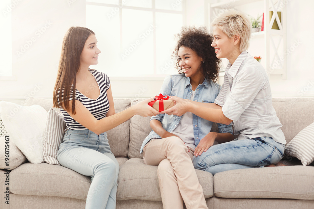 Excited woman getting gift from her friends Stock Photo | Adobe Stock