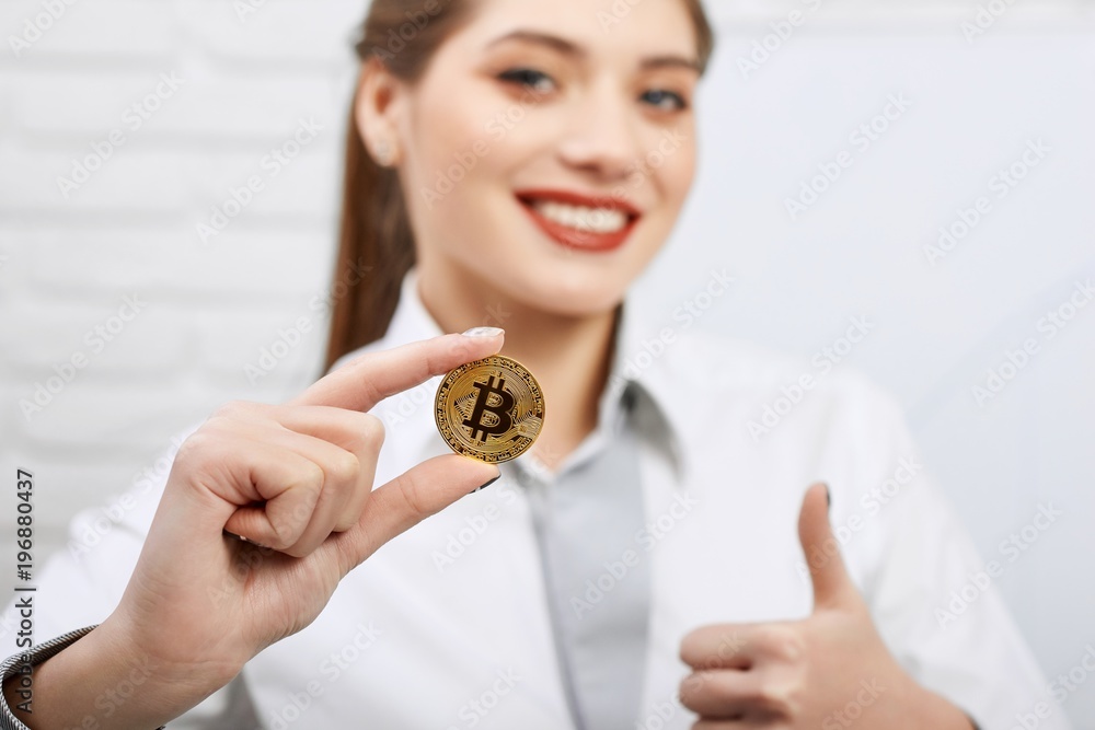 Gorgeous smiling woman holding golden bitcoin being main cryptocurrency ...