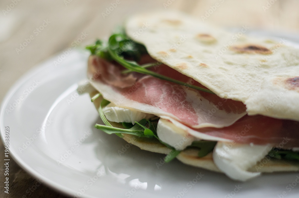 Homemade Italian flatbread called piadina with rocket salad, prosciutto ...