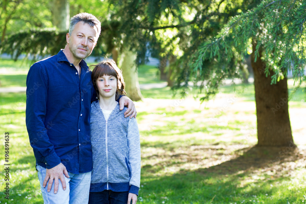 Handsome middle-aged man in park with his son. Attractive mid adult ...