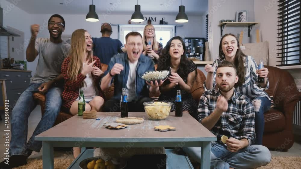 Video Stock Friends watch sports on TV, cheer and celebrate. Happy ...