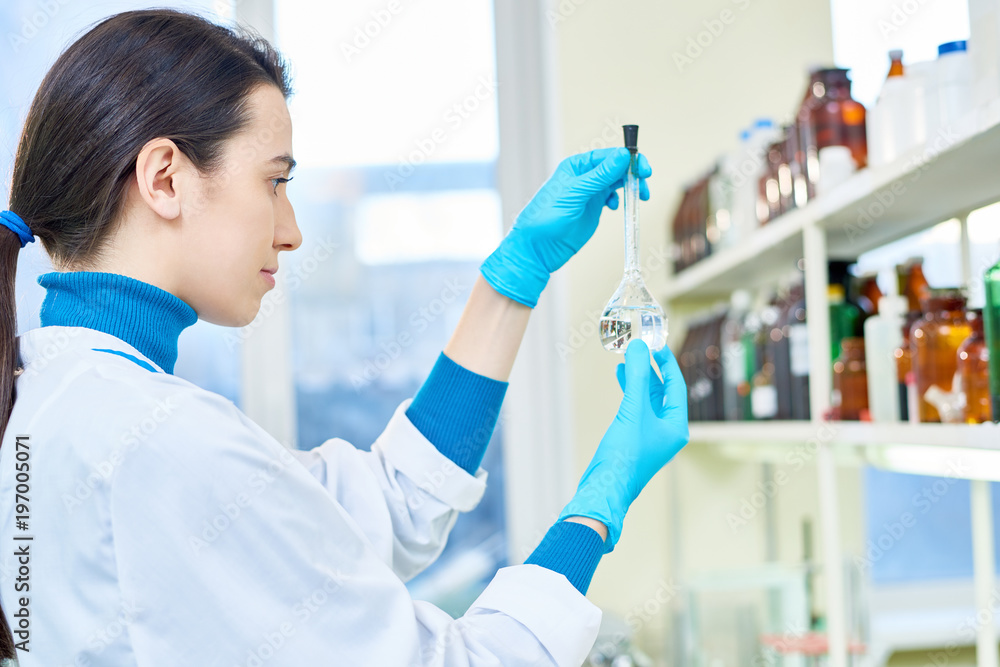Profile view of attractive young researcher wearing white coat and ...