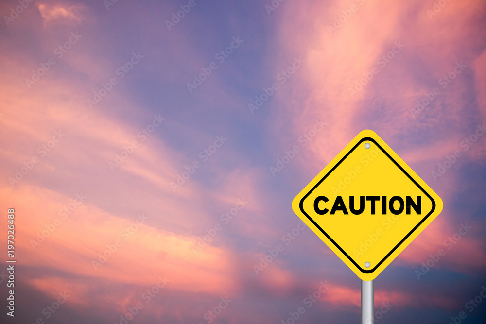 Yellow transportation sign post with caution word on violet sky with ...