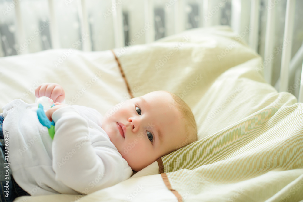 Funny baby in white crib with canopy. Nursery interior and bedding for ...