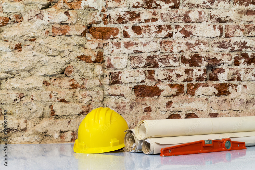 Construction of buildings: safety helmet and drawings project on brick ...