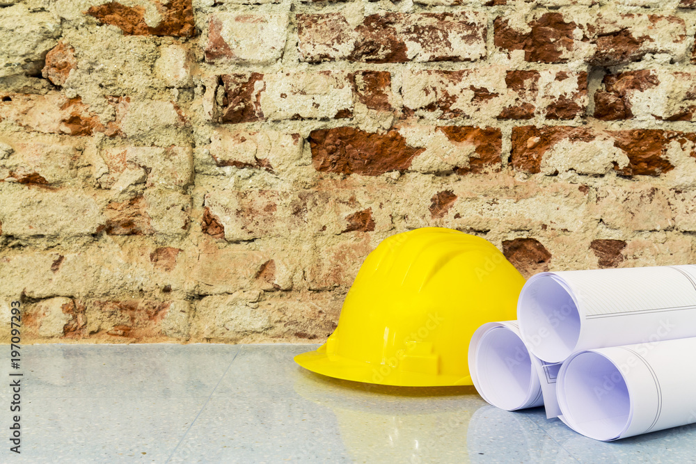 Construction of buildings: safety helmet and drawings project on brick ...