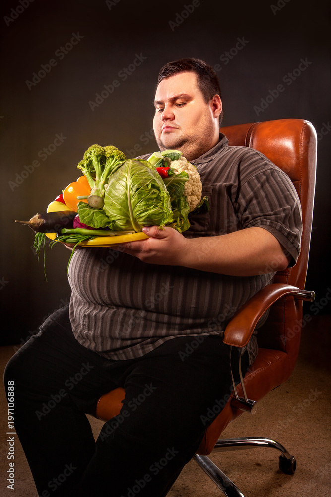Diet fat man eating healthy food with vegetables cauliflower and sweet ...