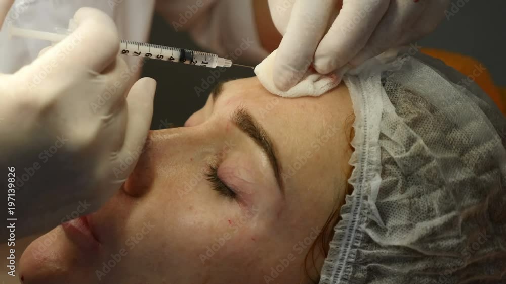 Beauty clinic. Beautician hands in gloves making face aging injection ...