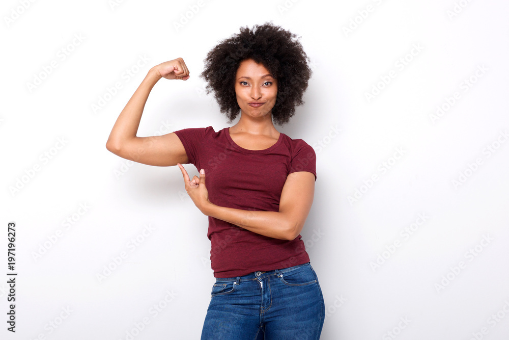 fit young african woman pointing at arm muscles on white background ...