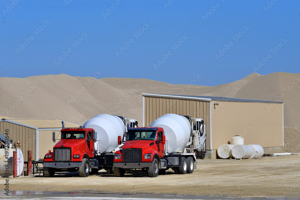 two cement mixer trucks waiting to be loaded Stock Photo | Adobe Stock