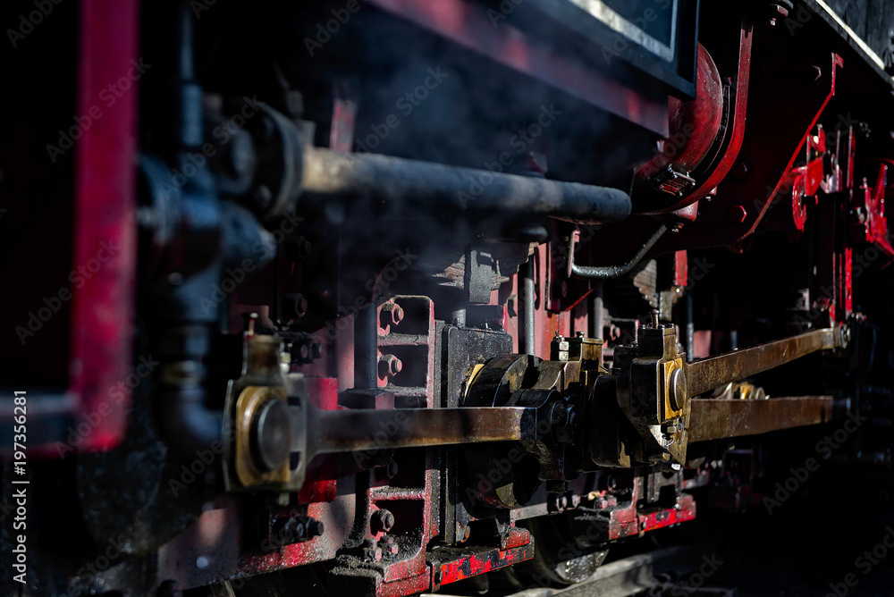 Mechanical parts of an old steam engine train car with oil and rust ...