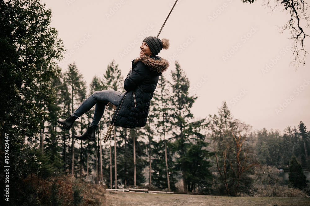 Girl swinging from forest rope swing Stock Photo | Adobe Stock