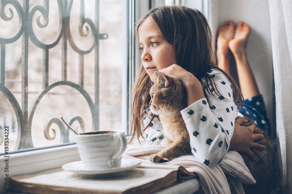 Child relaxing with a cat on a window sill Stock Photo | Adobe Stock