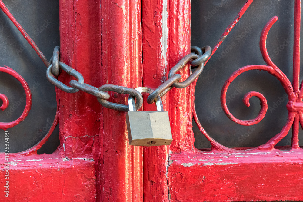 Closed red doors with old chain and lock. Stock Photo | Adobe Stock