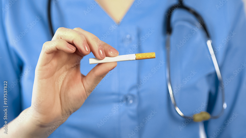 Female therapist showing cigarette, warning about health hazards of ...