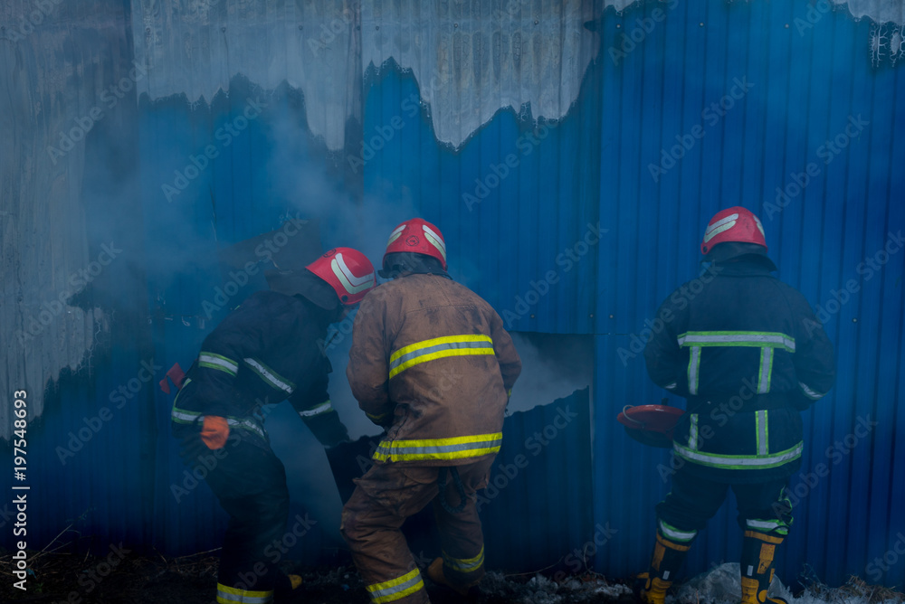 Firefighters work on an fire of building using a metal cutter rescue ...
