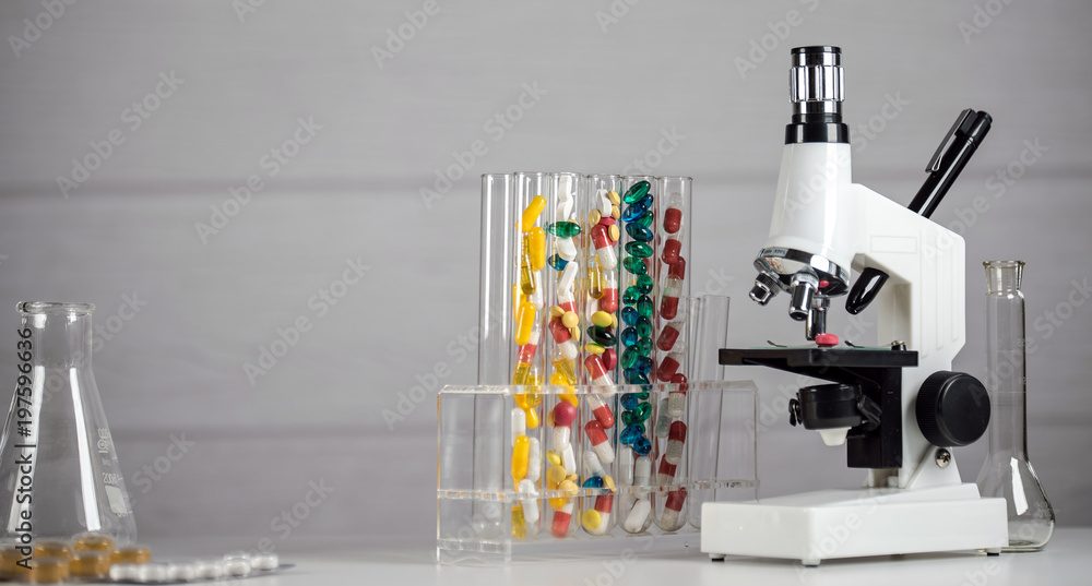 Laboratory Microscope, pills and test tubes. Scientific and healthcare ...
