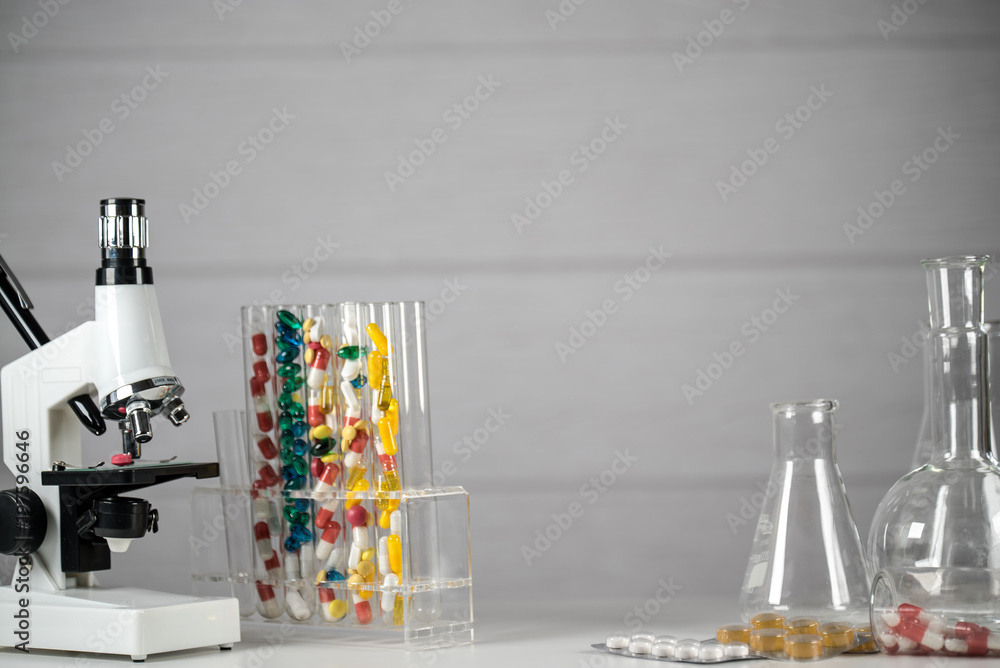 Laboratory Microscope, pills and test tubes. Scientific and healthcare ...