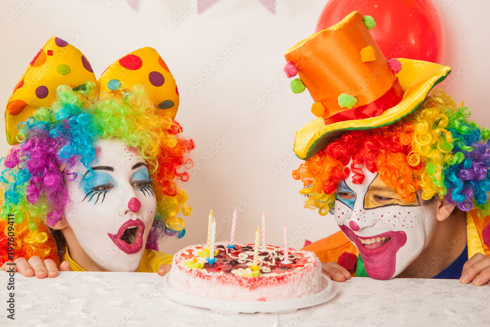 Clowns are a boy and a girl in bright costumes at the child's birthday ...