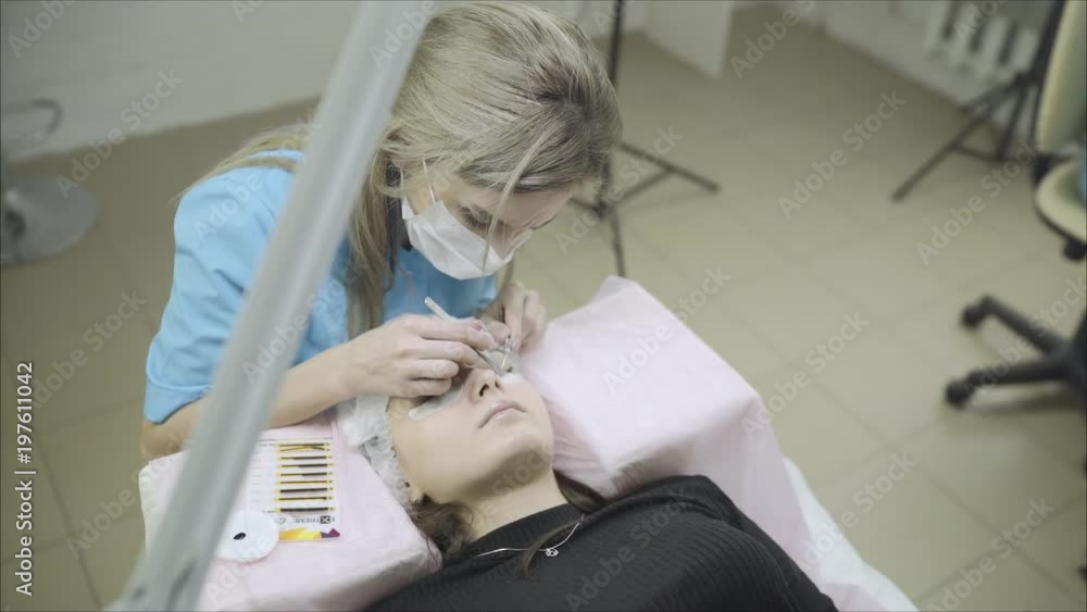 Eyelash extension in the beauty salon. The master increases eyelashes ...