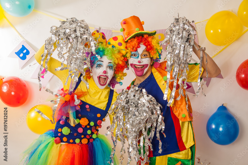 Clown girl and clown boy in bright costumes at the baby's birthday ...