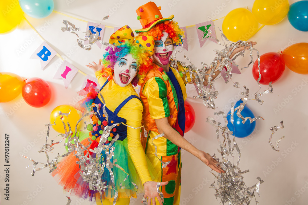 Clown girl and clown boy in bright costumes at the baby's birthday ...