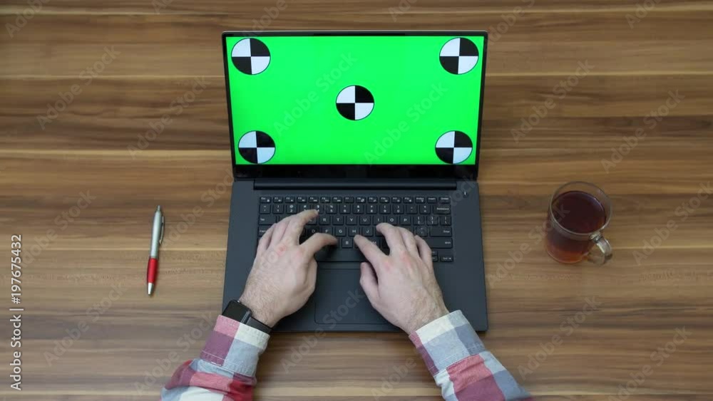 Top view on the office table with laptop computer with green screen and ...