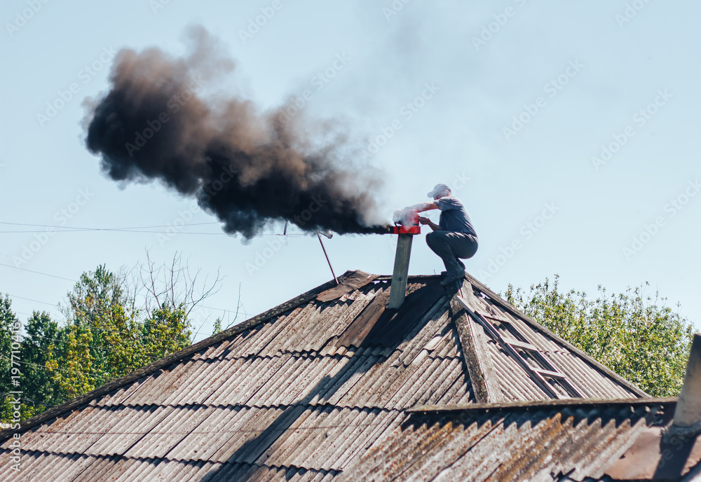Chimney sweep man in work uniform cleaning chimney on roof Stock Photo ...